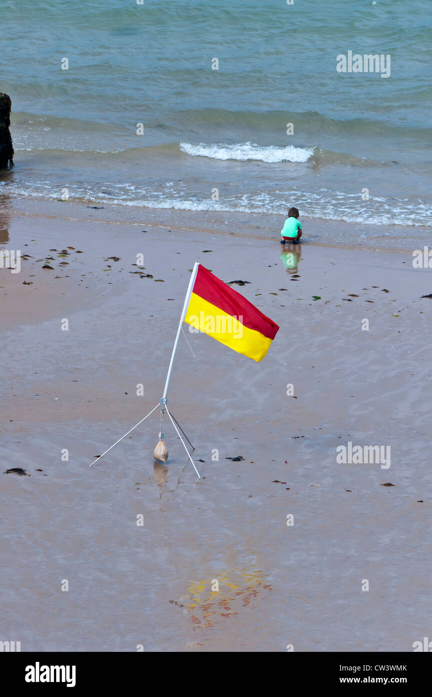 Red and yellow flag on the beach hi-res stock photography and images ...