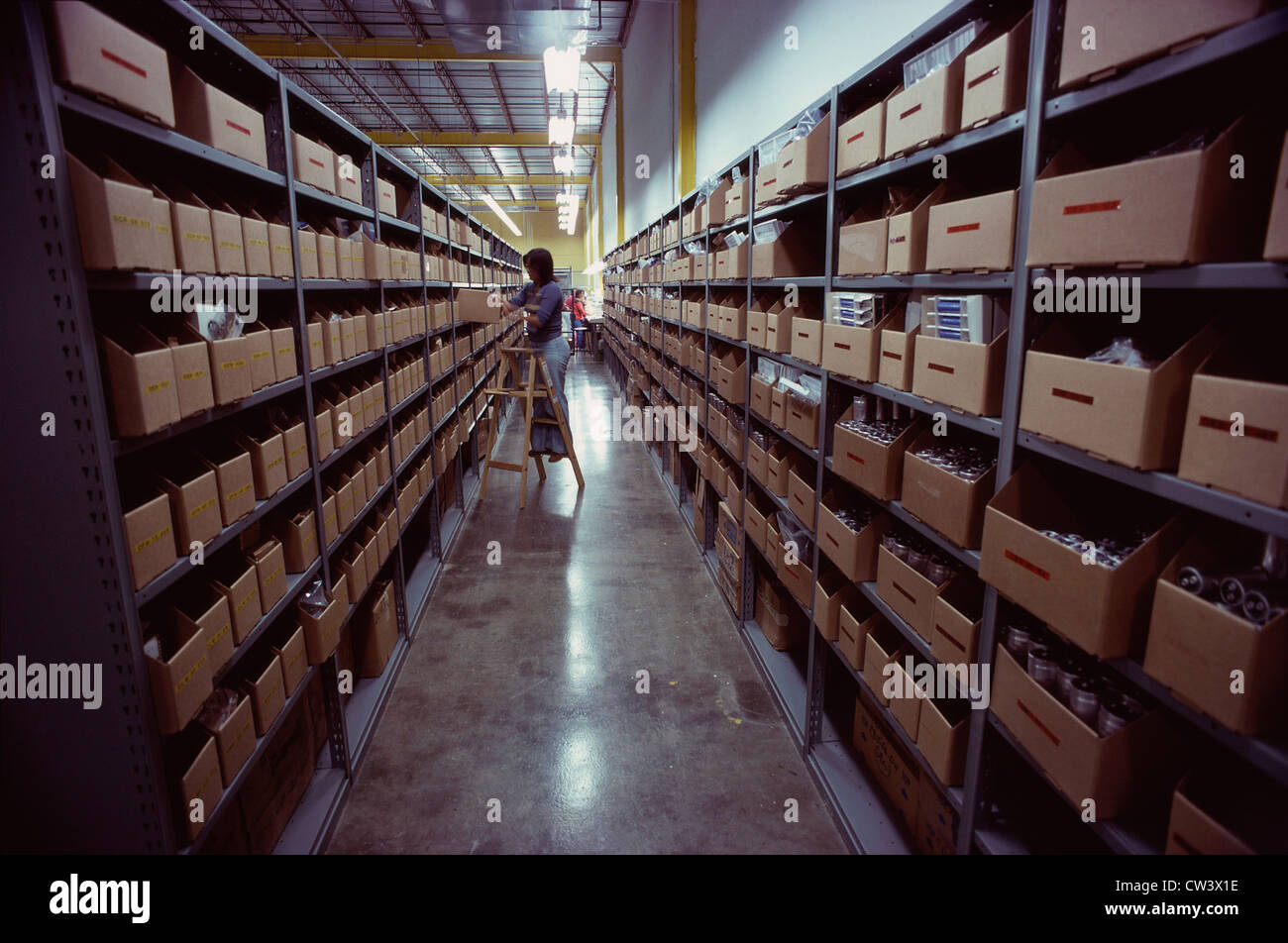 Woman arranging boxes in a warehouse Stock Photo - Alamy