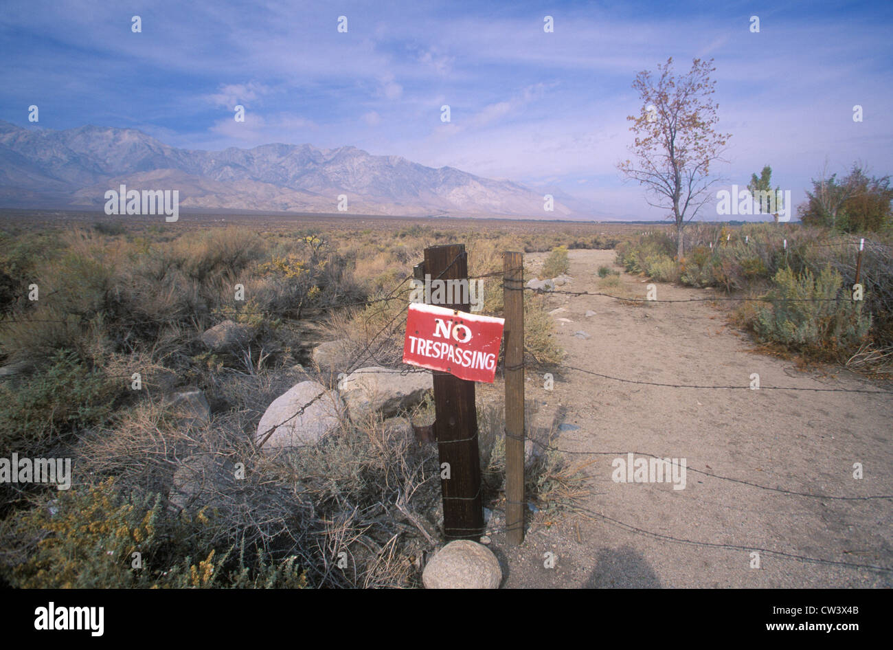 No trespassing sign at dirt road toward the Sierra Mountains ...