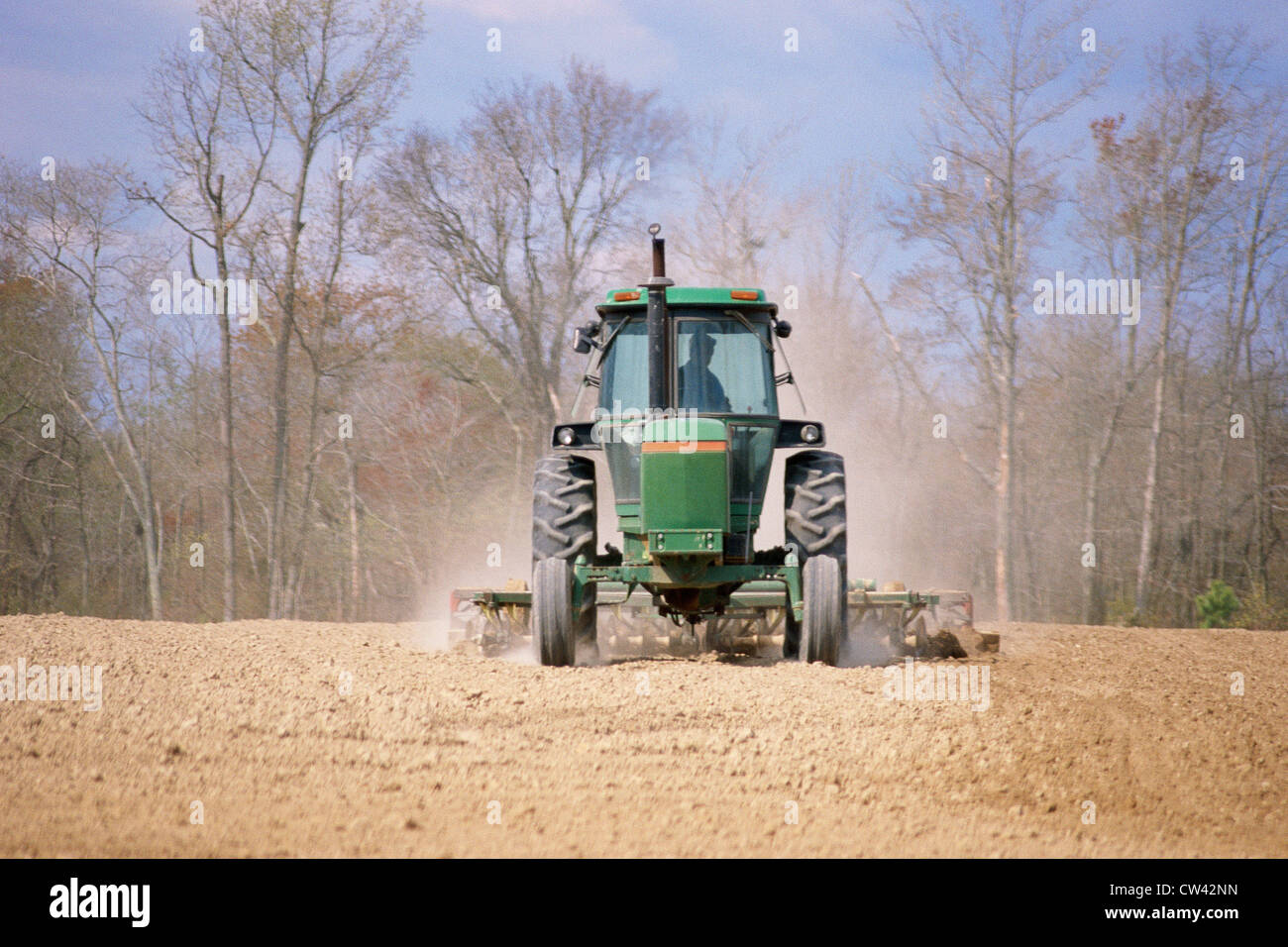 Tractor kicking up dust in field Stock Photo - Alamy