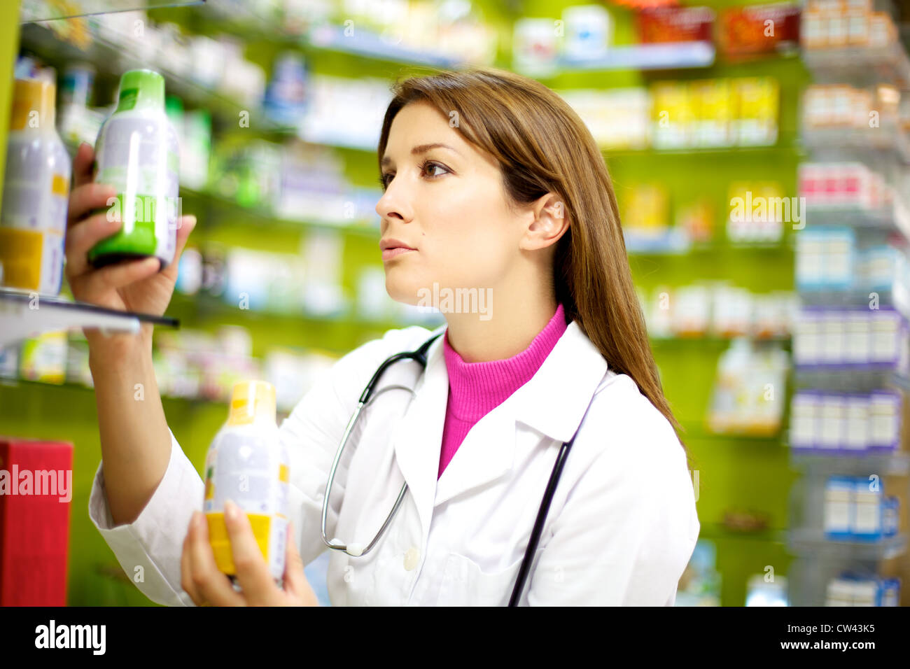 young good looking doctor putting order in her pharmacy with medicine ...