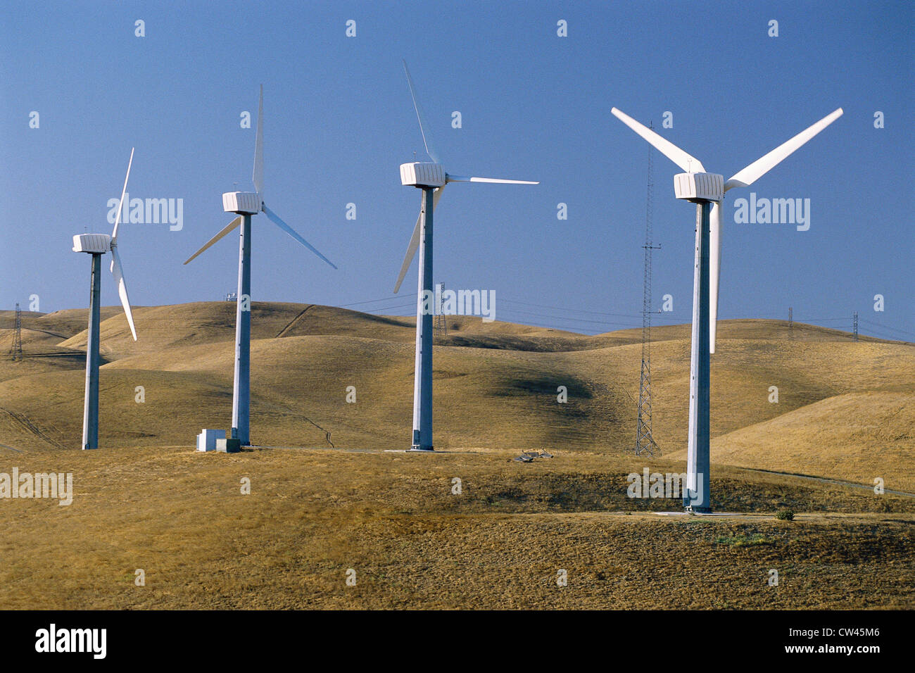 Row of wind turbines standing on ground Stock Photo - Alamy