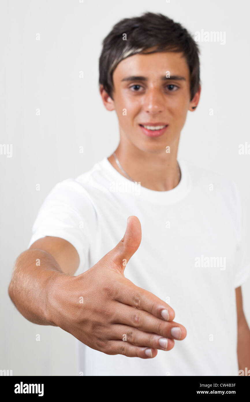 young swarthy man with brown eyes giving hand for greeting on white ...