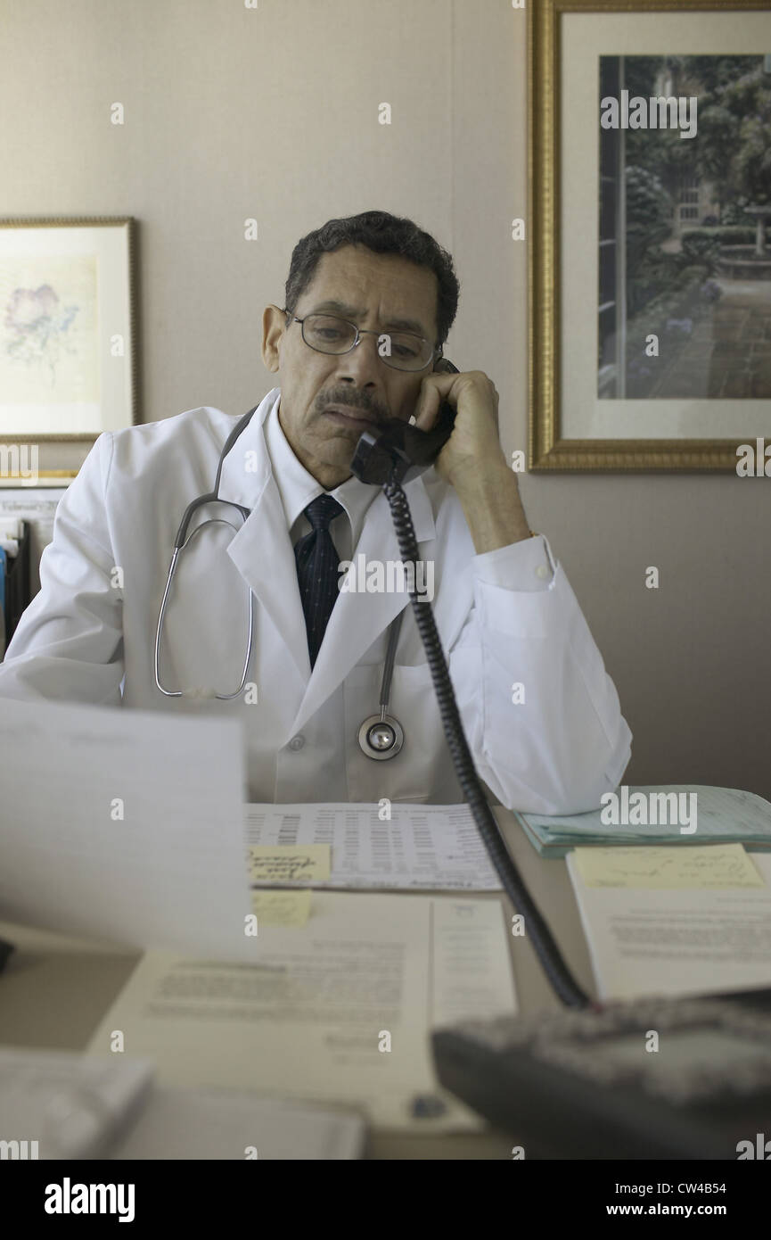 Male doctor talking on a landline telephone Stock Photo - Alamy