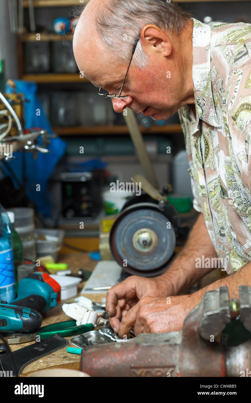Senior working in workshop with different tools Stock Photo - Alamy