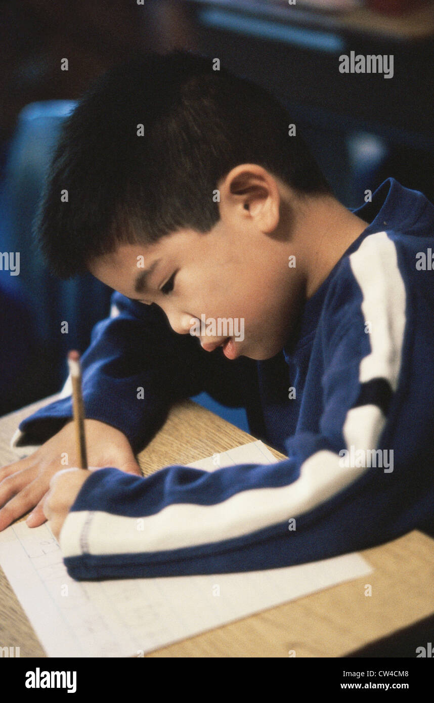 Boy writing on a paper with a pencil Stock Photo - Alamy