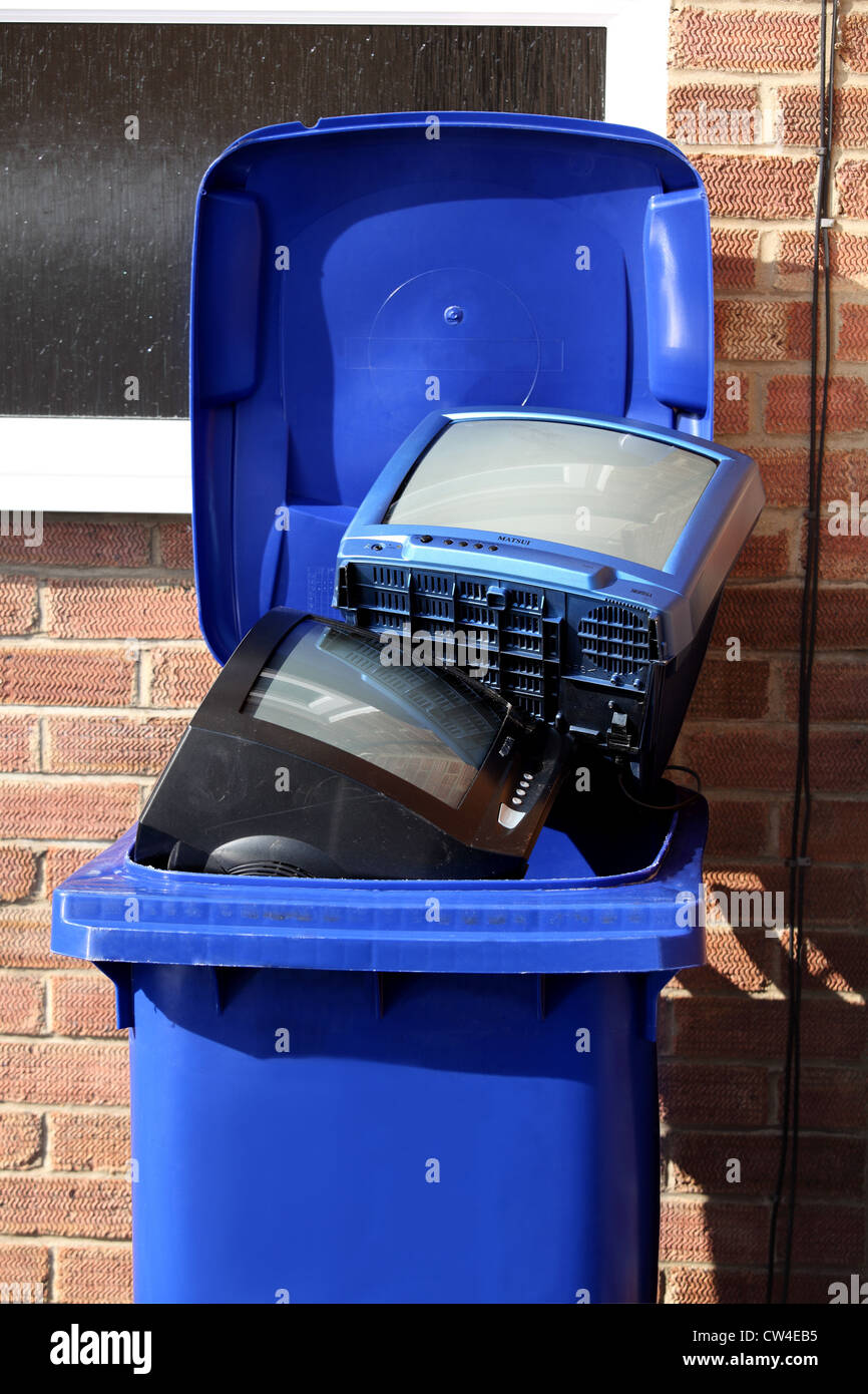 Two old analogue televisions are thrown away in a waste/recycle bin ...