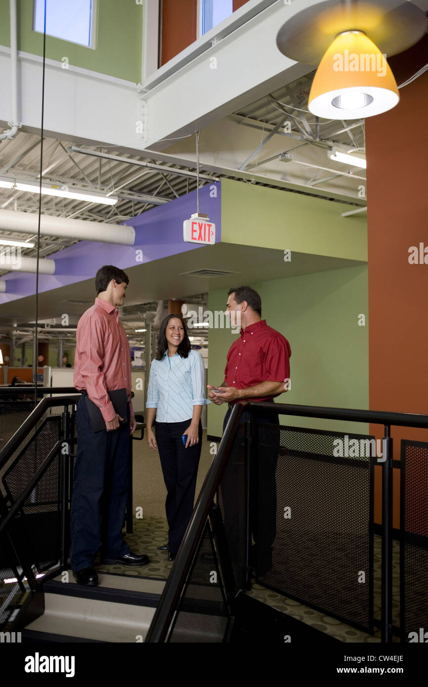 Two businessmen and a businesswoman standing on stairs Stock Photo - Alamy