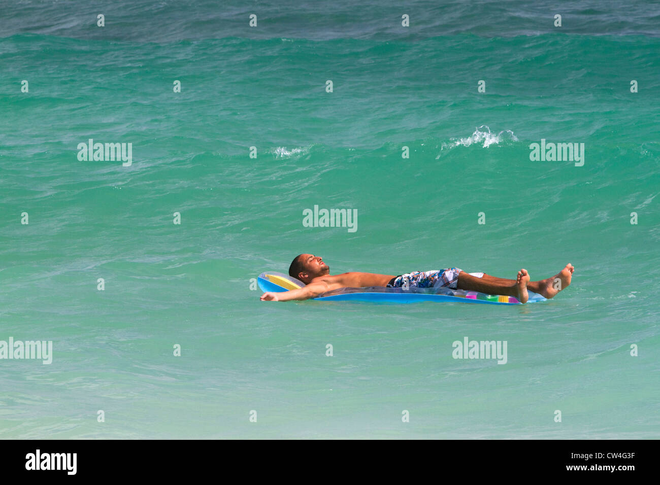 Man floating on an air matress in the Gulf of Thailand at Chaweng beach ...