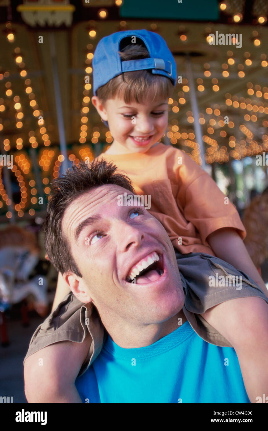 Son sitting on his father's shoulders Stock Photo - Alamy