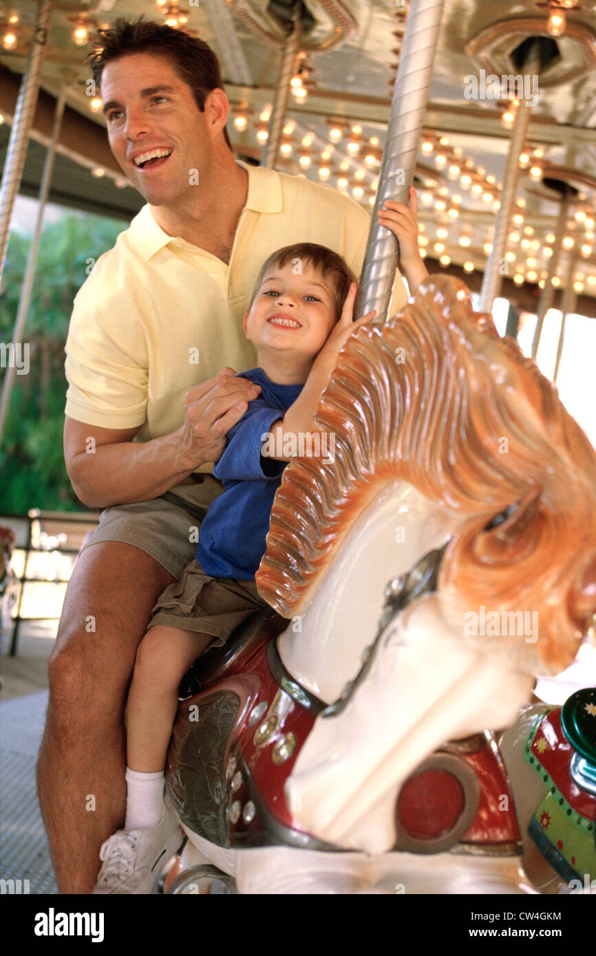 Father and son sitting on a carousel Stock Photo - Alamy