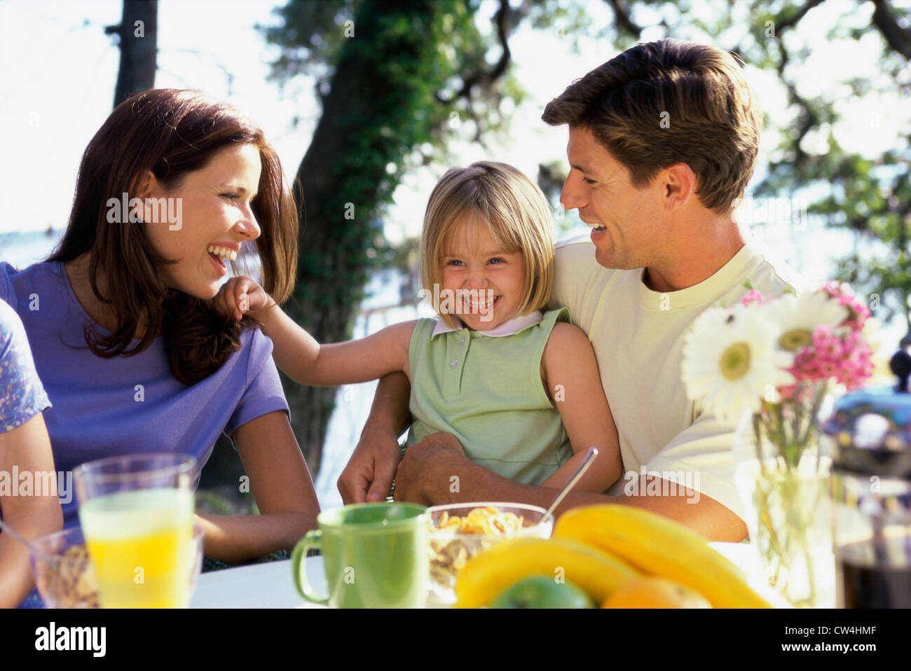 Parents sitting with their daughter and smiling Stock Photo - Alamy