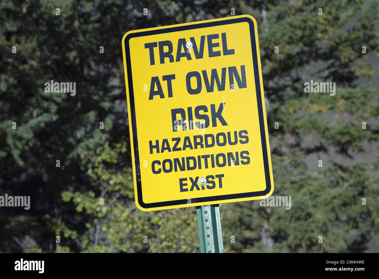 Yellow warning sign reading Travel At your own Risk alerting travelers ...