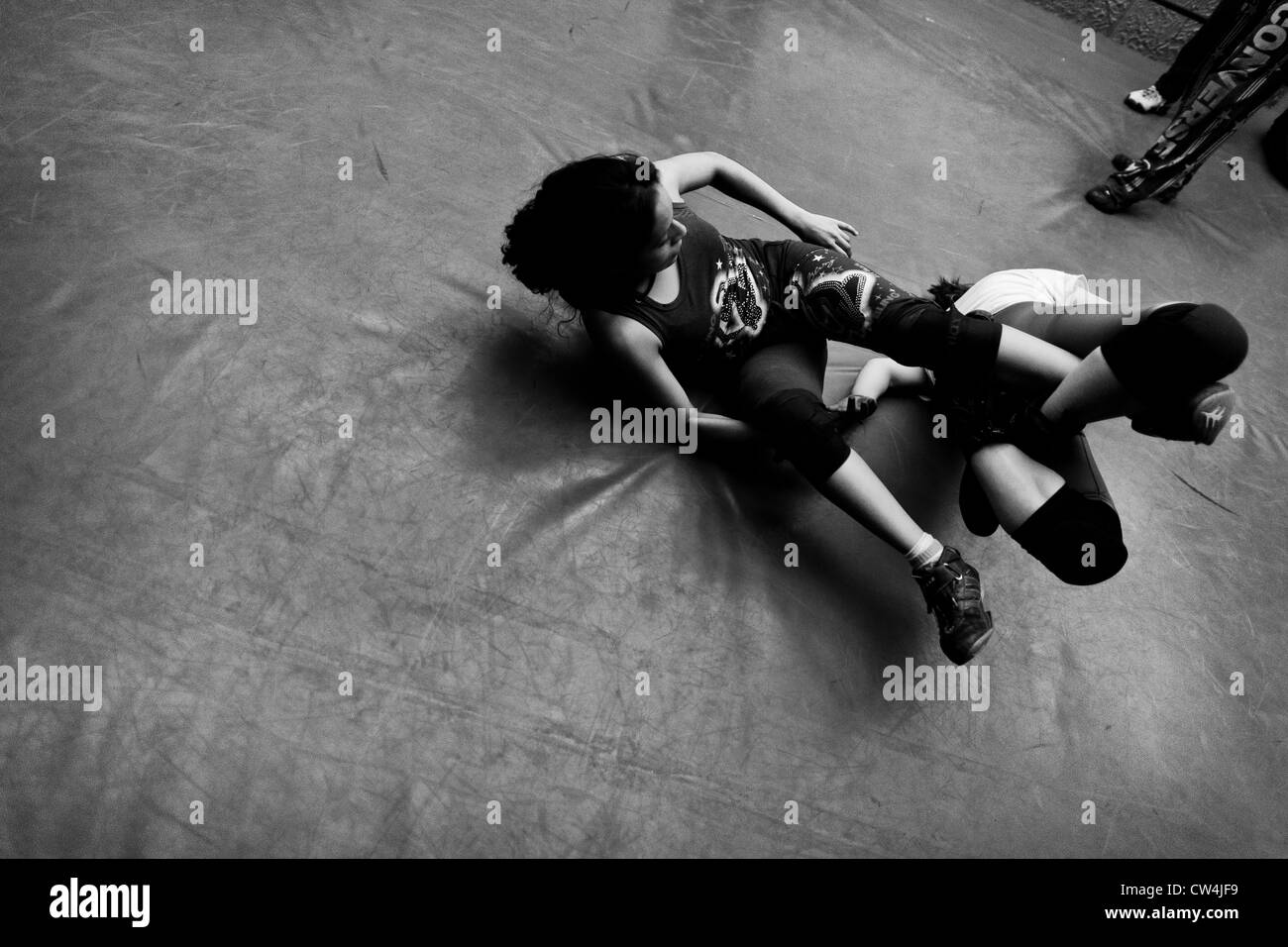 A female Lucha libre wrestler locks her sparring partner in a hold ...