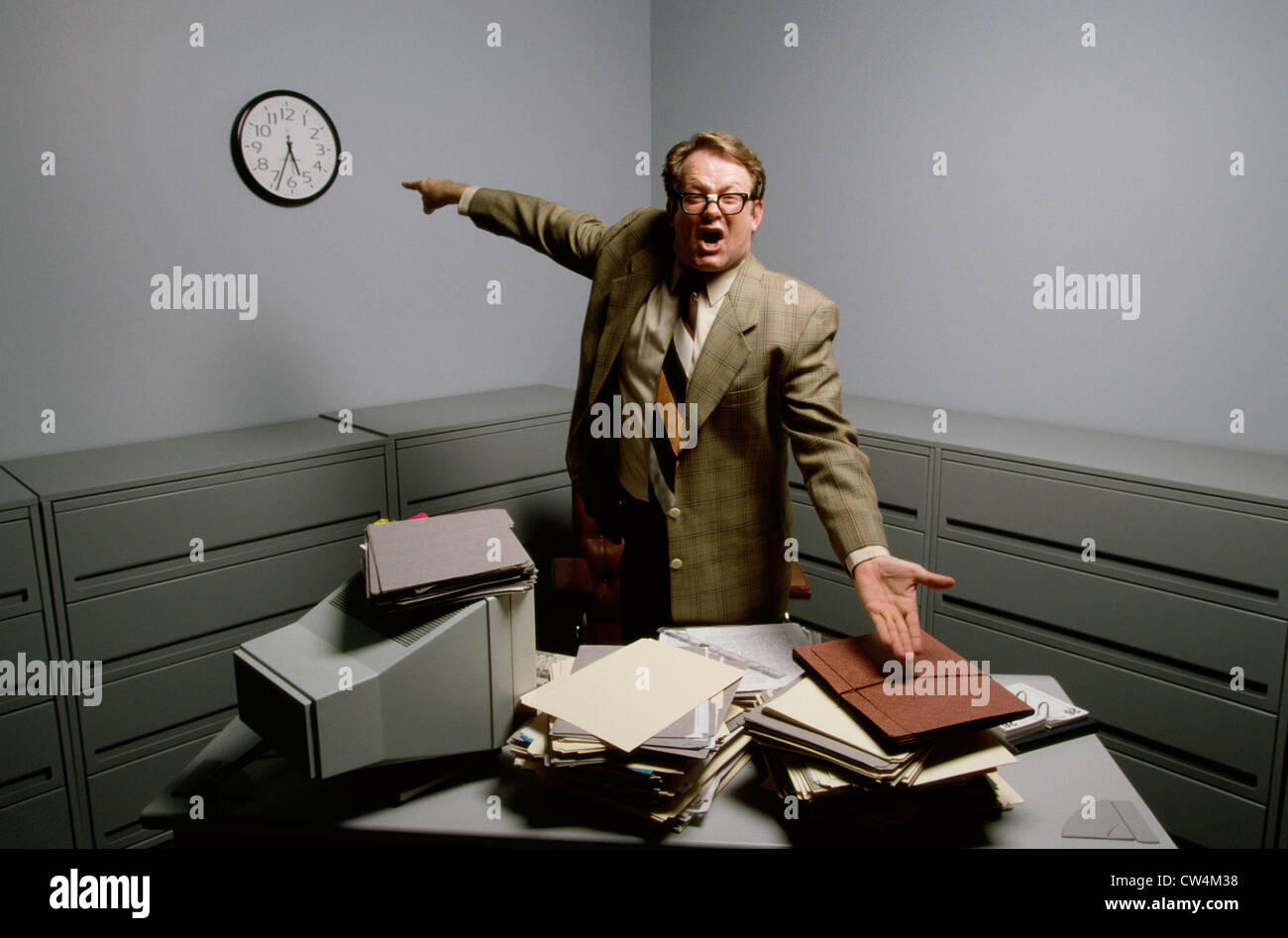Portrait of a businessman pointing at a clock in anger Stock Photo - Alamy