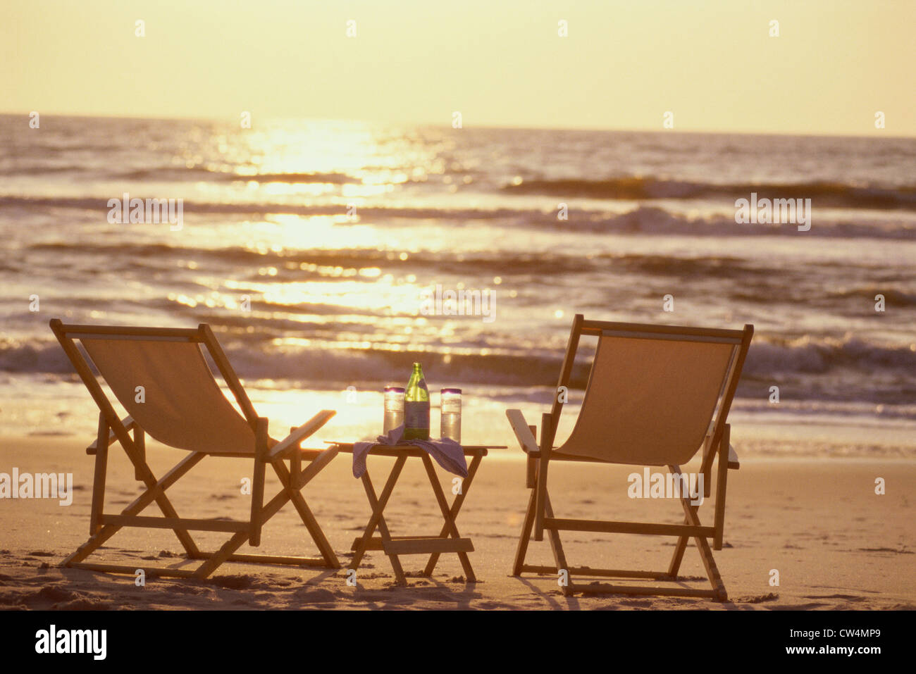 Rear view of two deck chairs on the beach at sunset Stock Photo - Alamy