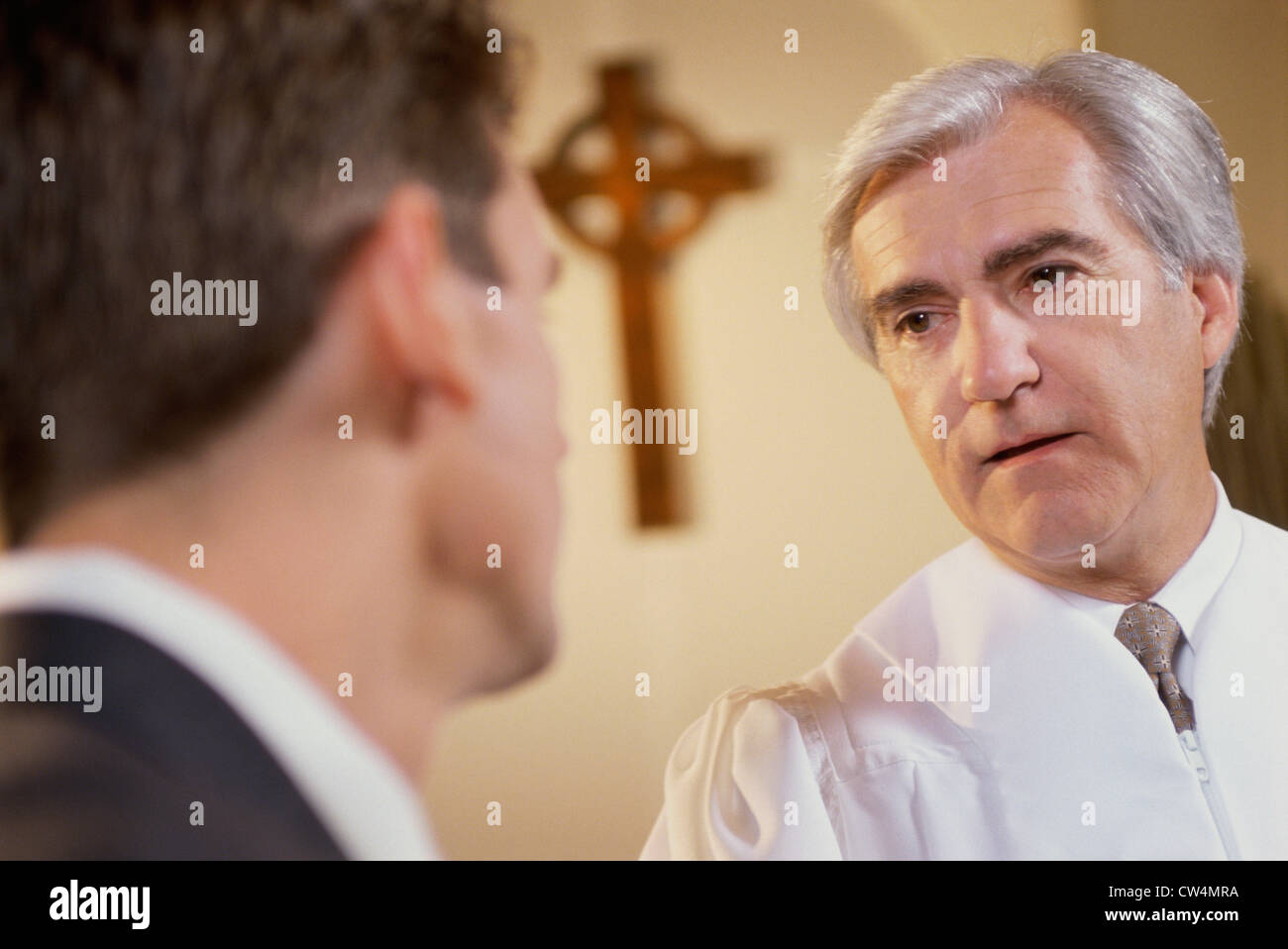 Close-up of a priest talking to a man Stock Photo - Alamy