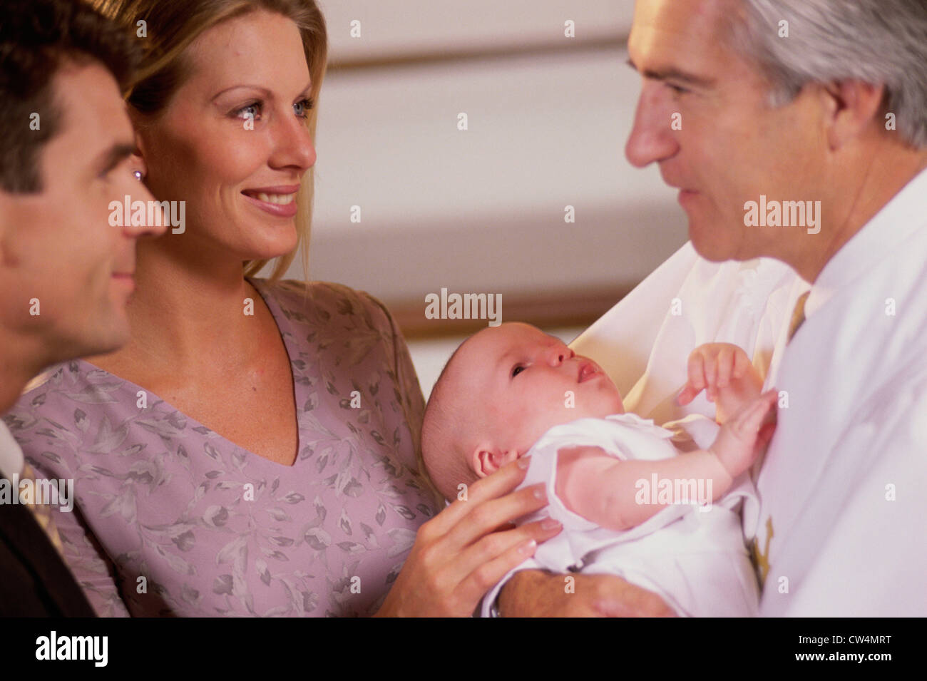 Close-up of parents with their son at a baptism Stock Photo - Alamy