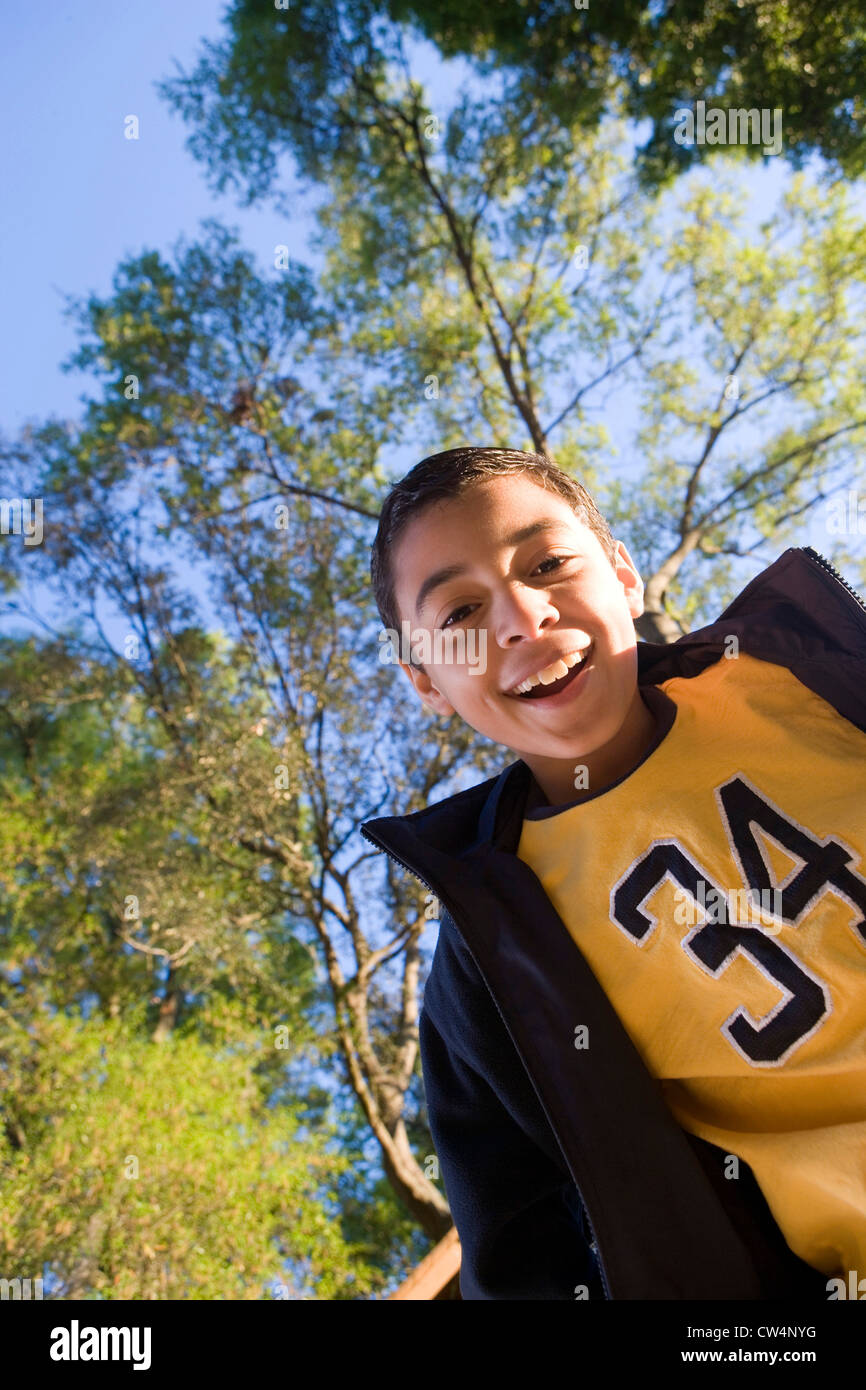 Portrait of a cheerful boy smiling against a tree Stock Photo - Alamy