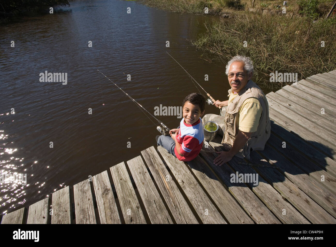 Portrait of a grandfather fishing with his grandson at the lake Stock ...