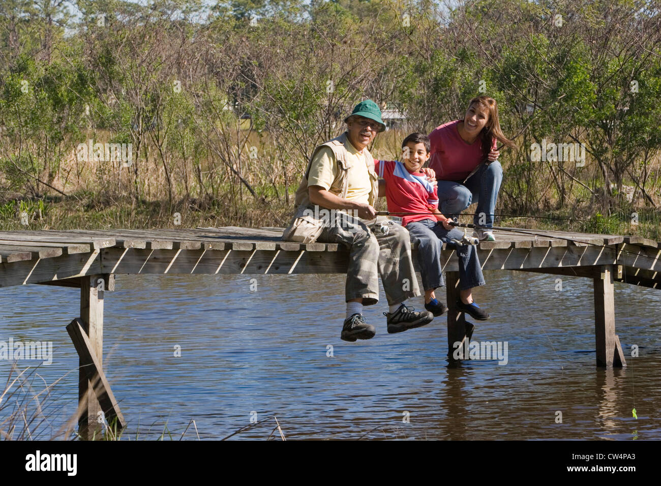 Portrait of a grandfather fishing with his grandson at the lake Stock ...