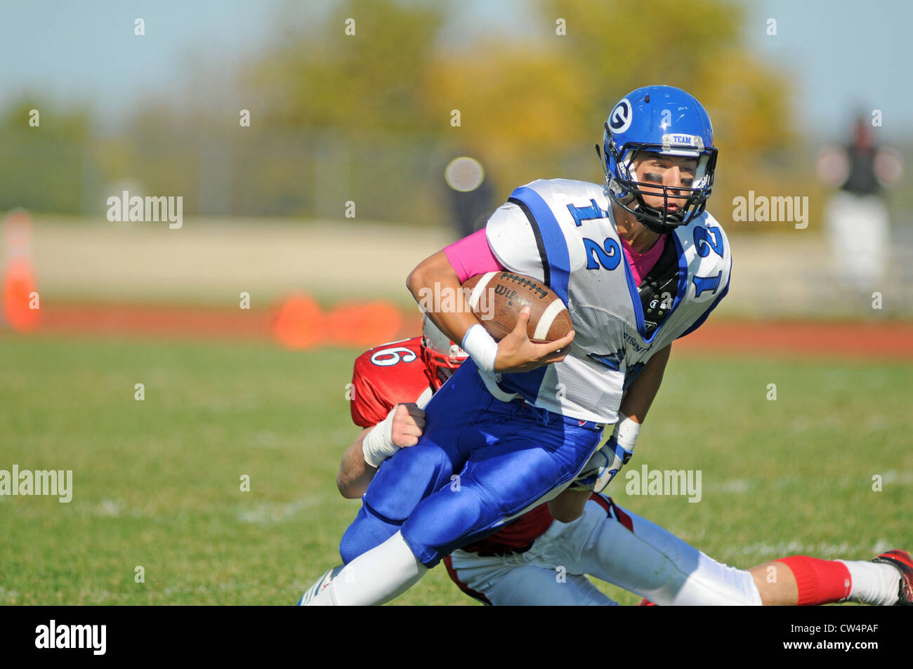 Football Quarterback being dragged down from behind after trying to ...