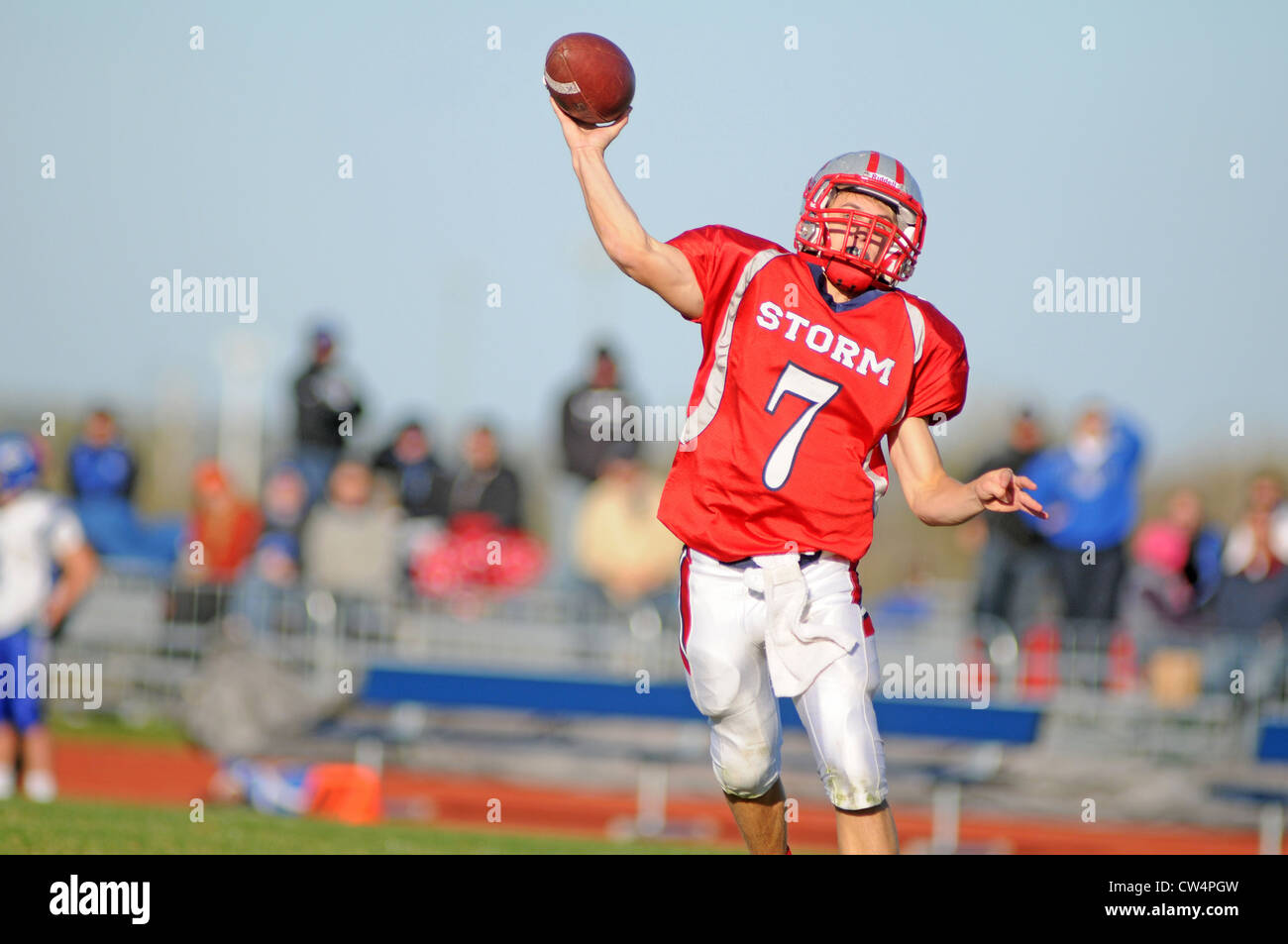 Football quarterback delivers a pass after rolling out during a high ...