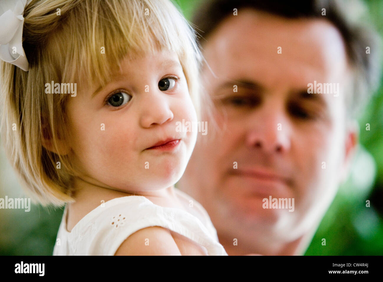 Portrait of a girl with her father in the background Stock Photo - Alamy