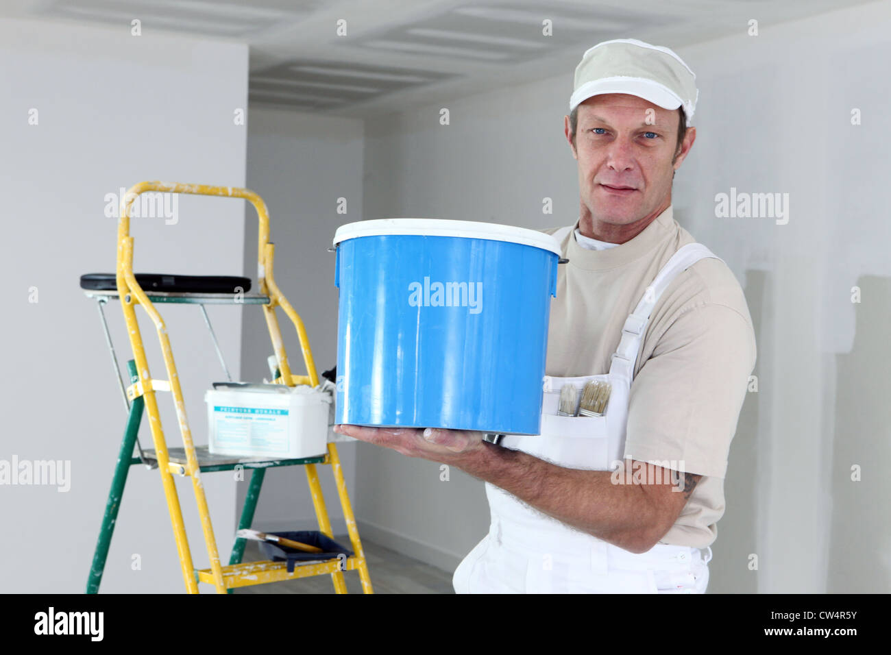 Painter holding a can of paint Stock Photo - Alamy