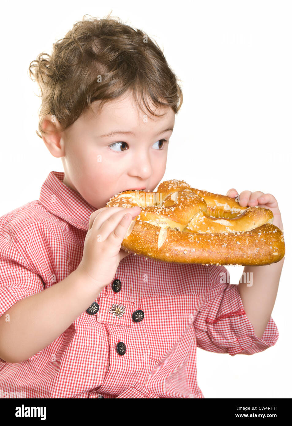 Little boy eats traditional German bagel - Bretsel Stock Photo - Alamy