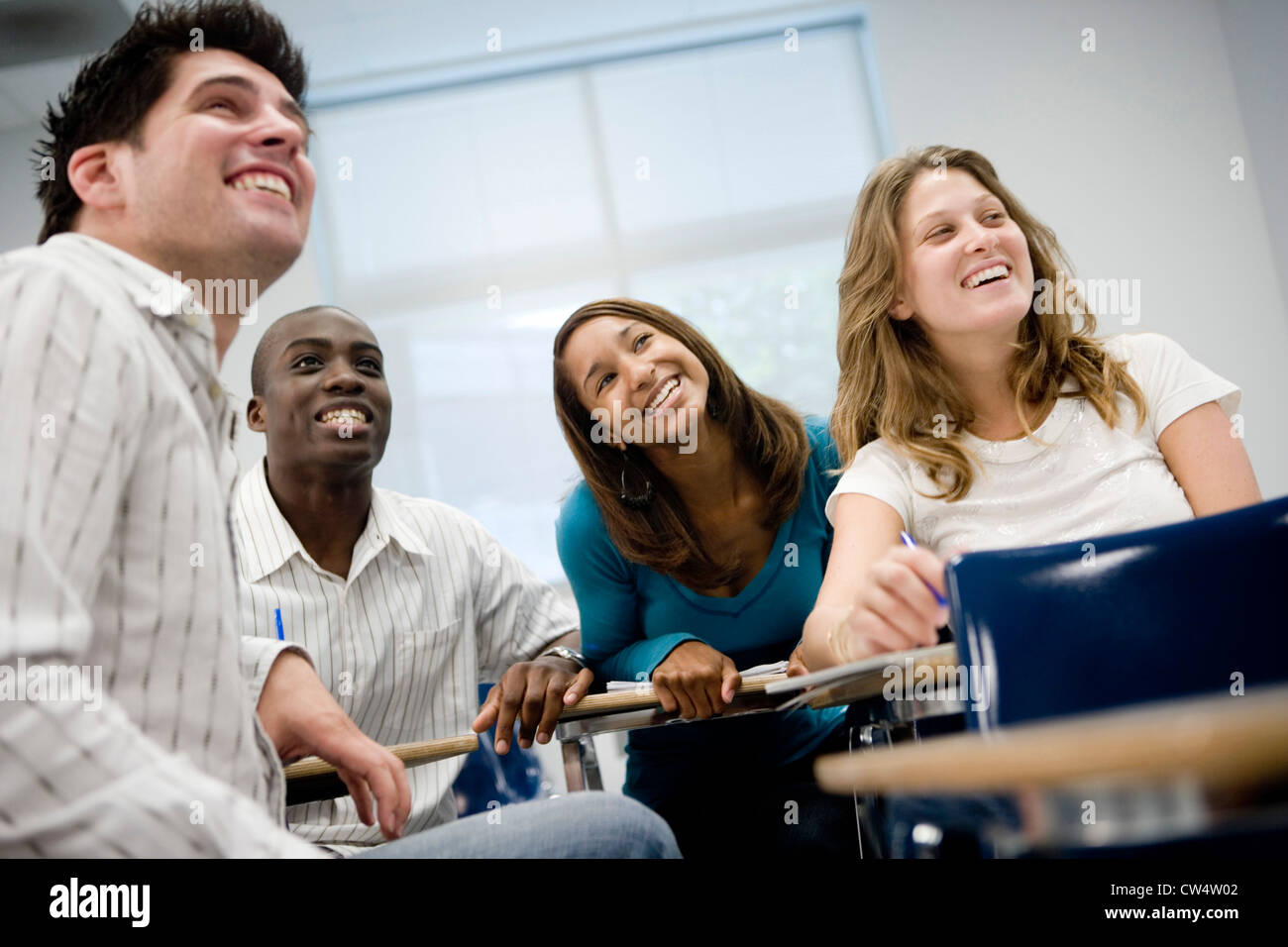 University students attending lecture in the classroom and smiling ...