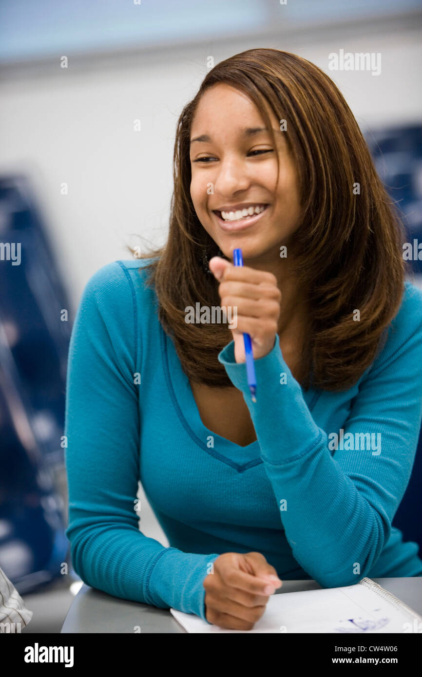 Cheerful female student holding a pen in the classroom Stock Photo - Alamy