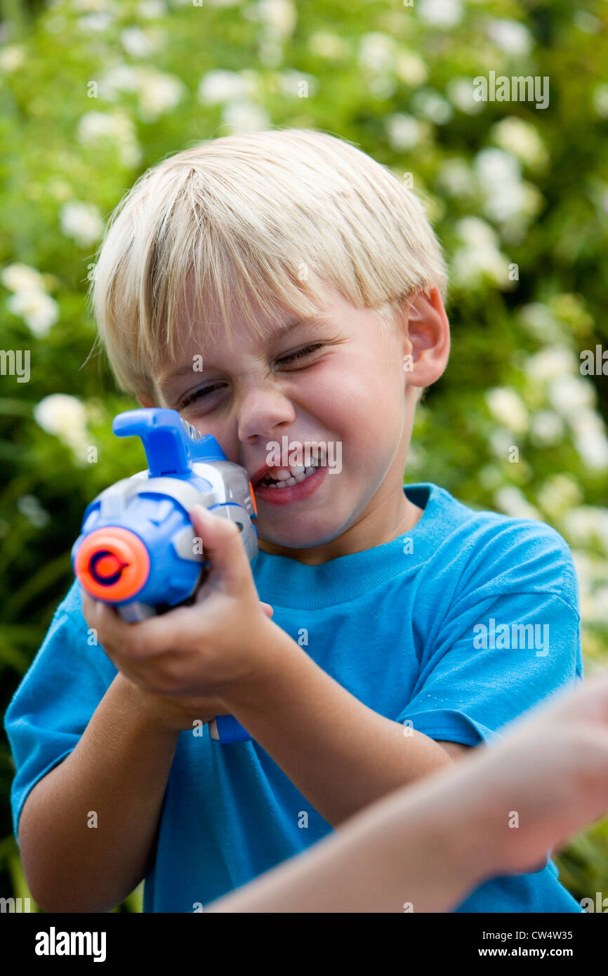 Close-up of a boy holding toy gun Stock Photo - Alamy