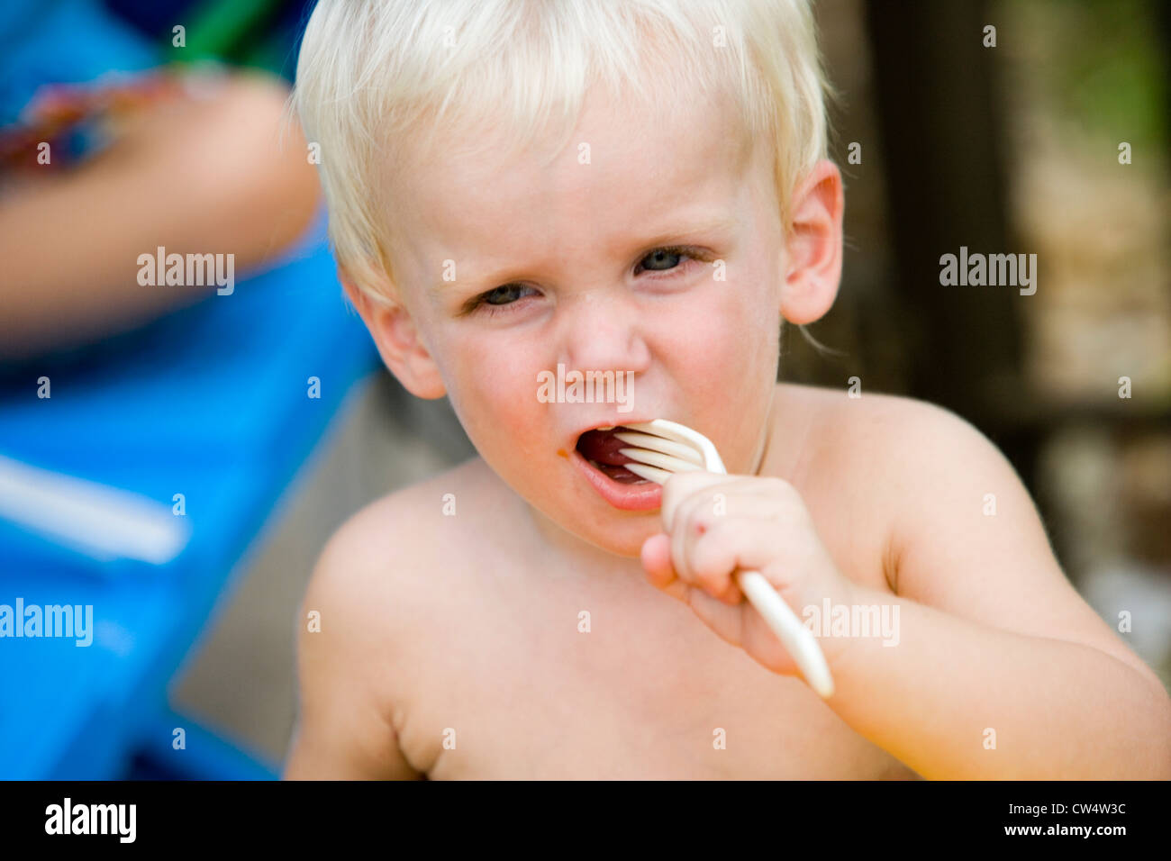 Close-up of a shirtless boy biting folk Stock Photo - Alamy