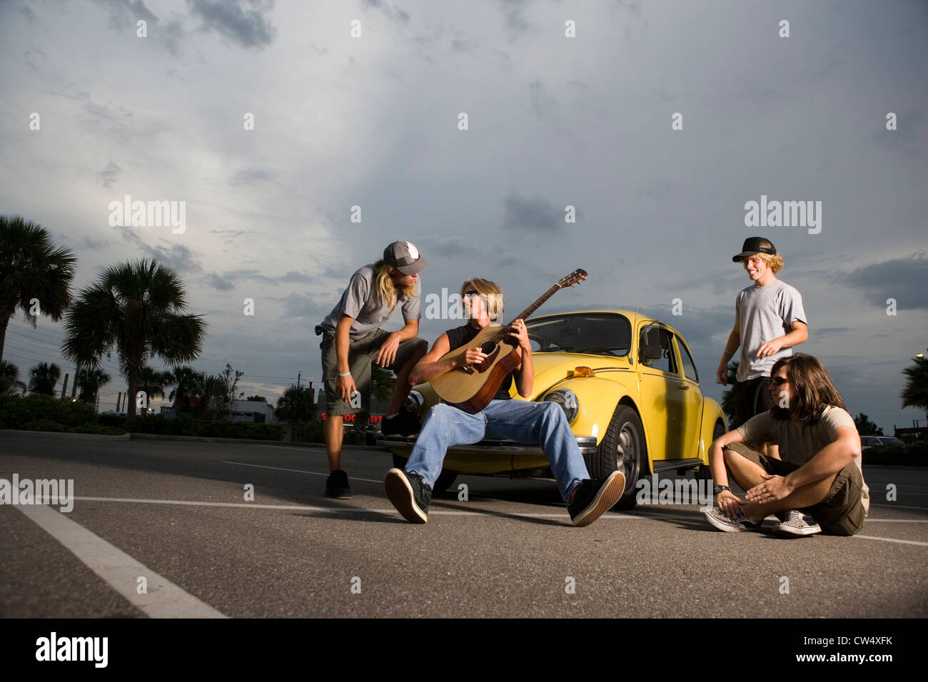 Friends enjoying music by a car at the parking area Stock Photo - Alamy