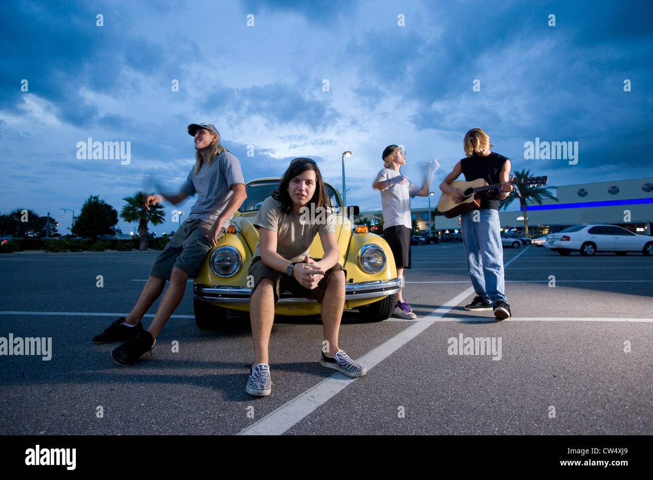 Friends enjoying music by a car at the parking area Stock Photo - Alamy