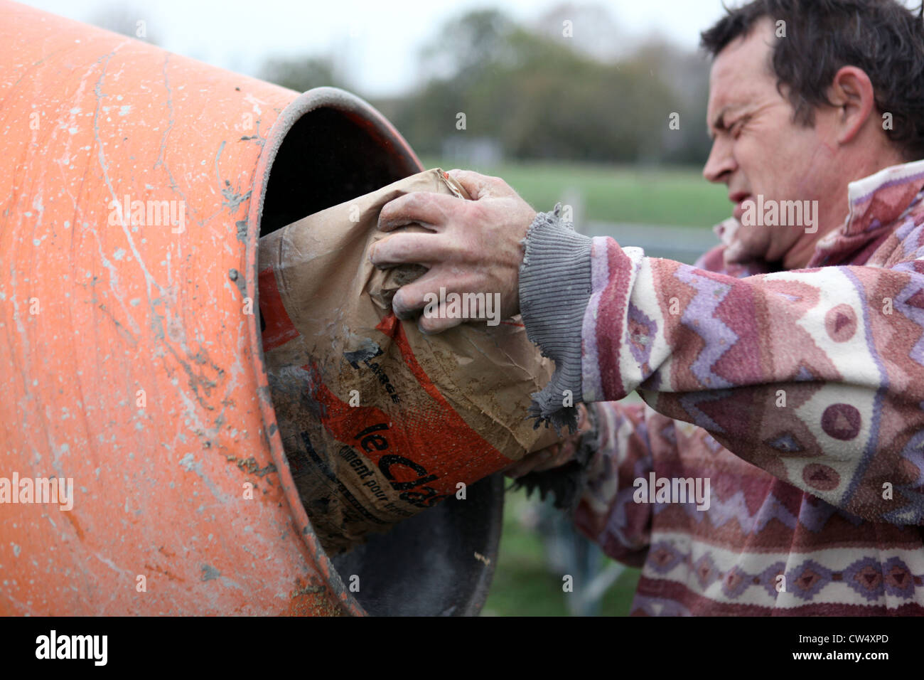 Man putting cement in a mixer Stock Photo - Alamy