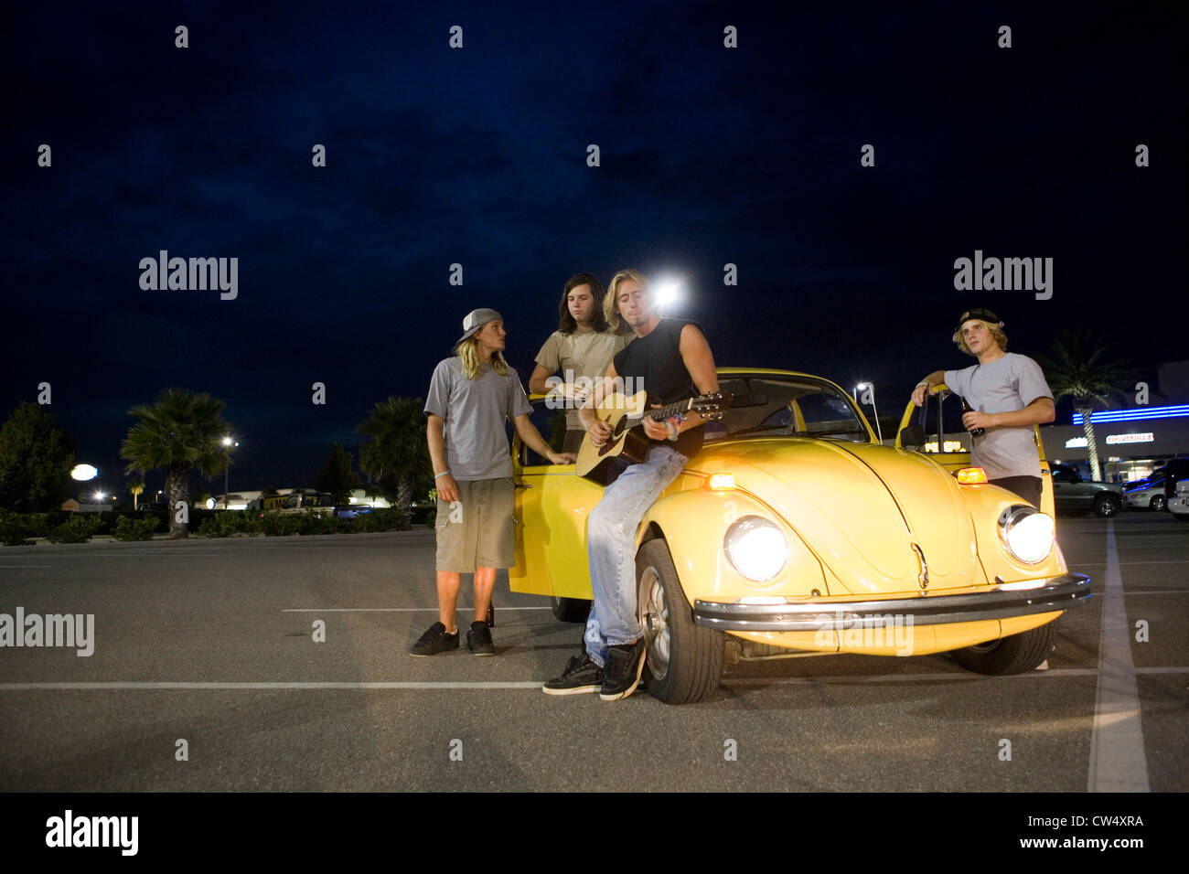 Friends enjoying music by a car at the parking area Stock Photo - Alamy