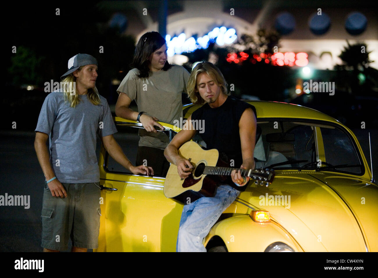 Friends enjoying music by a car at the parking area Stock Photo - Alamy