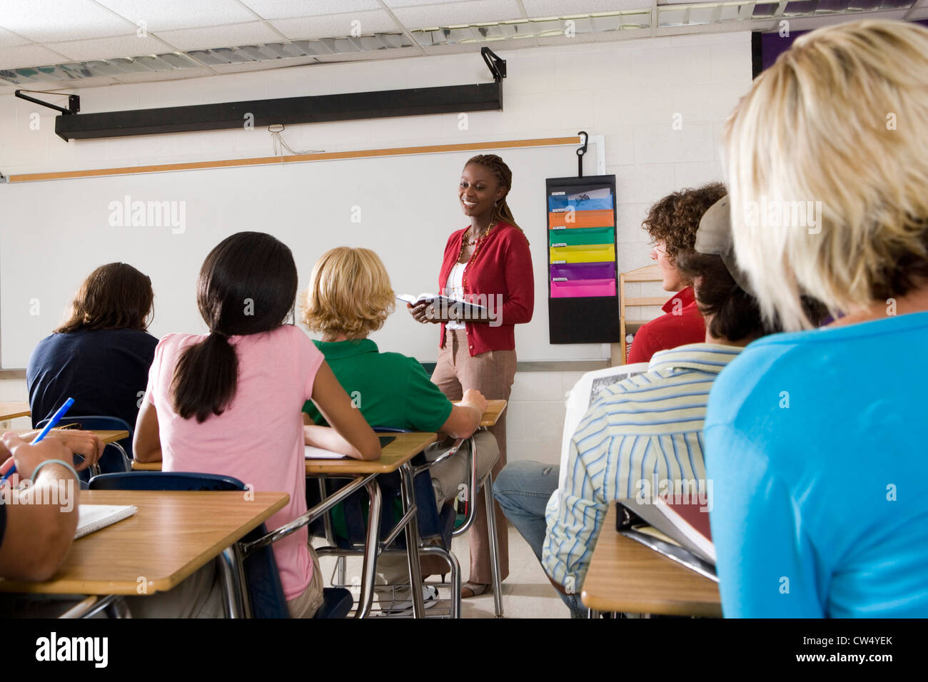 Cheerful female teacher teaching students in the classroom Stock Photo ...