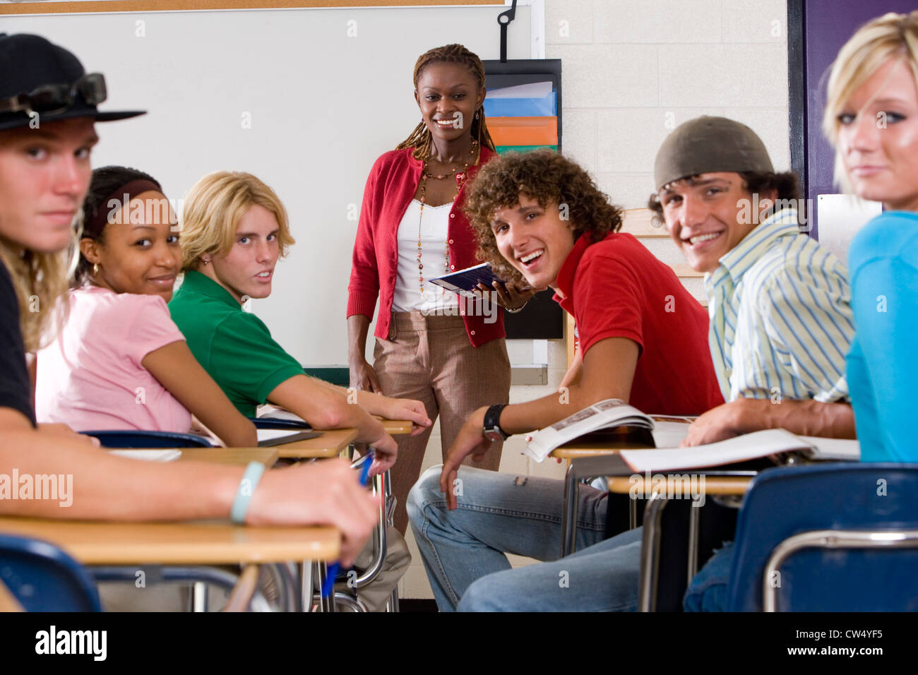 Cheerful female teacher teaching students in the classroom Stock Photo ...