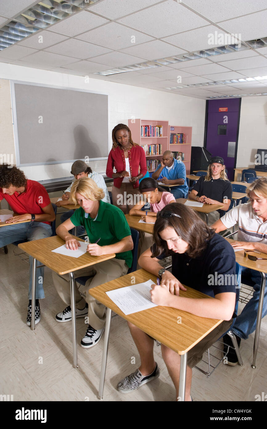 Female teacher supervising during exam in the classroom Stock Photo - Alamy