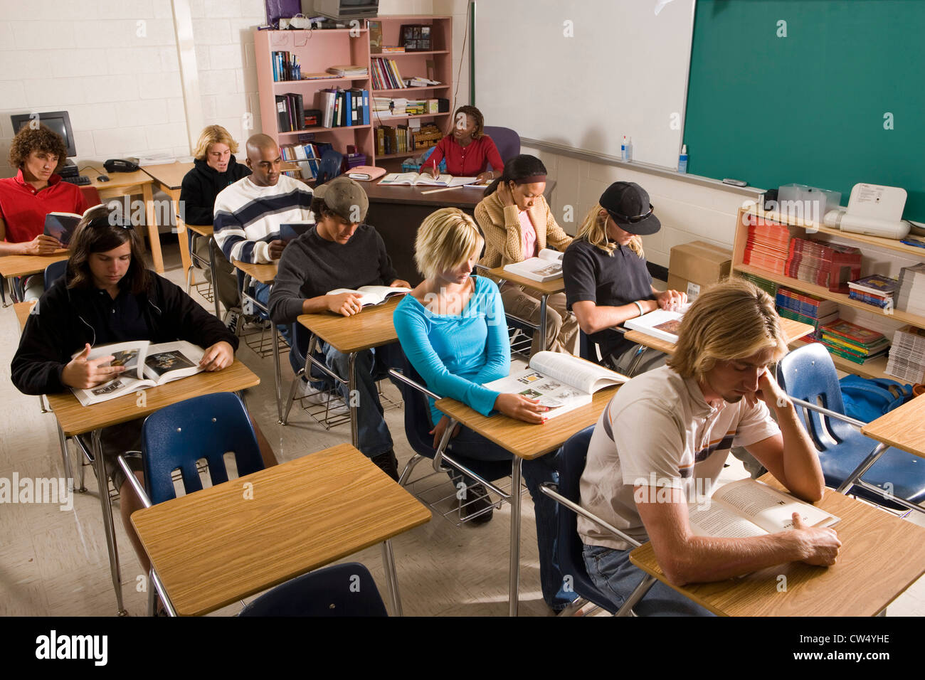 Students reading book in the classroom Stock Photo - Alamy
