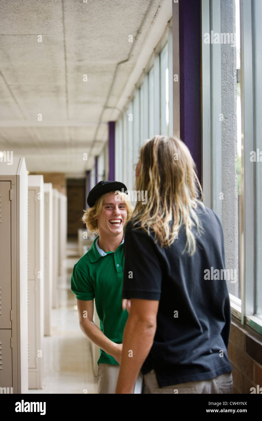 Cheerful male students standing by locker in corridor Stock Photo - Alamy