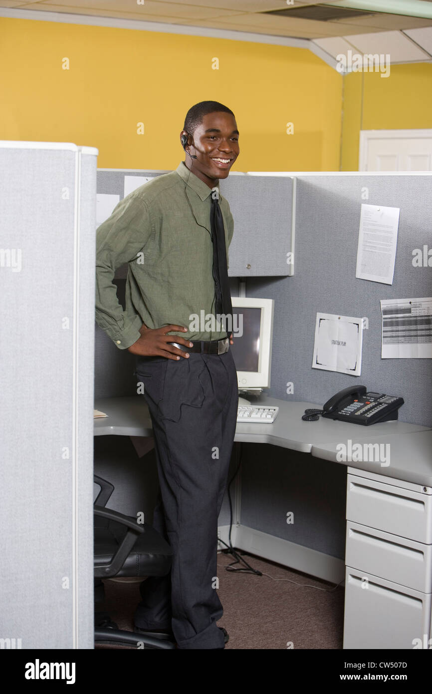 Young man standing by a computer in an office Stock Photo - Alamy