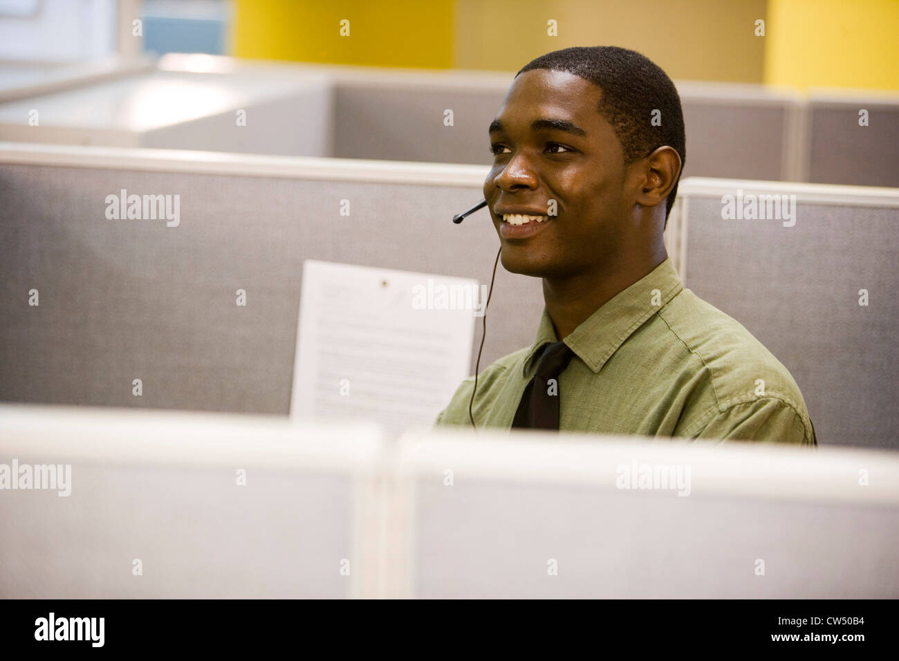 Young man using headset in an office Stock Photo - Alamy