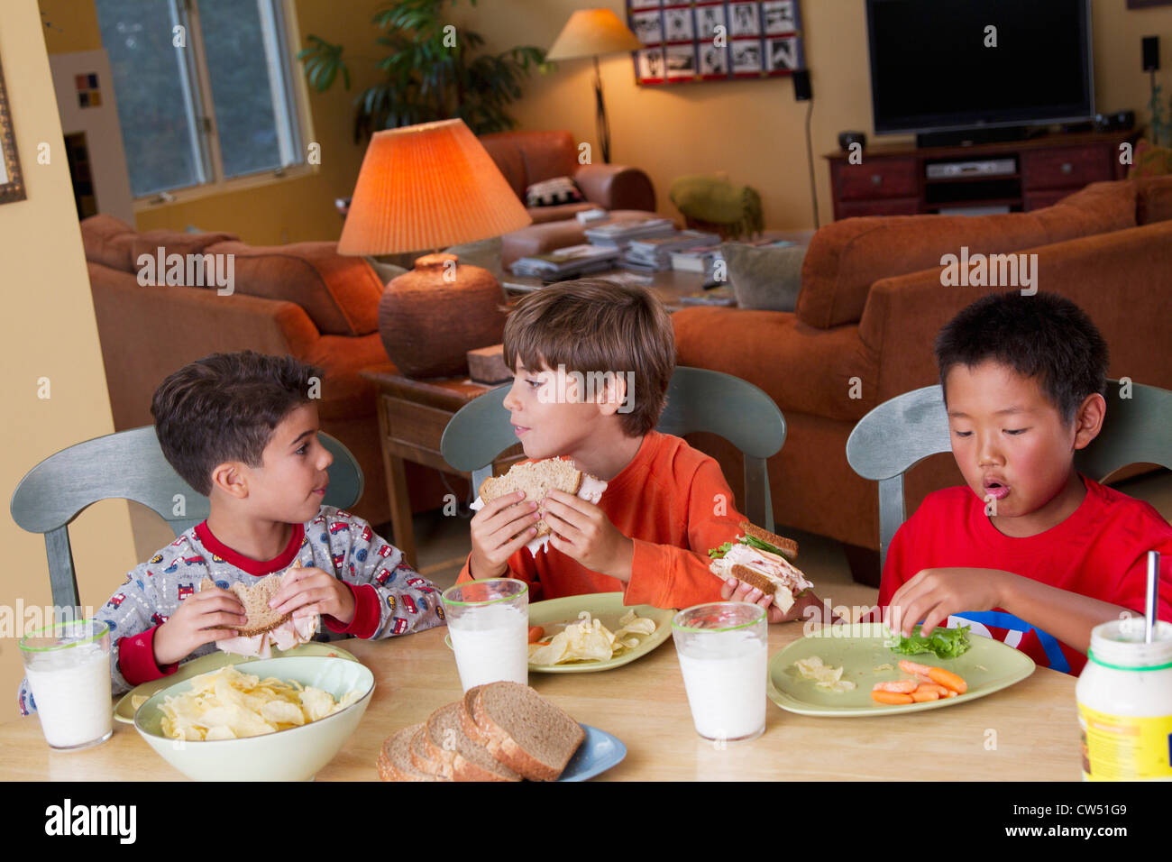 Boys eating lunch together Stock Photo - Alamy