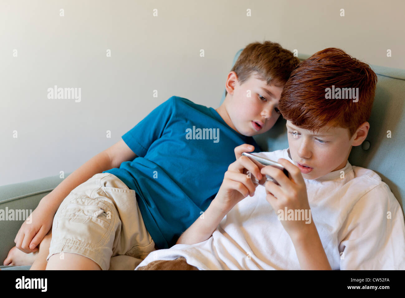 Boys playing on cell phone Stock Photo - Alamy
