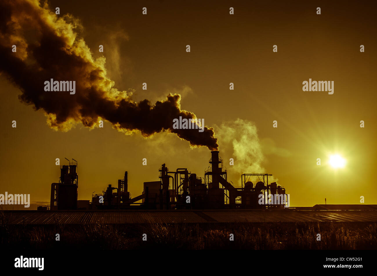 Smoking chimney at sunset on industrial buildings complex Stock Photo ...