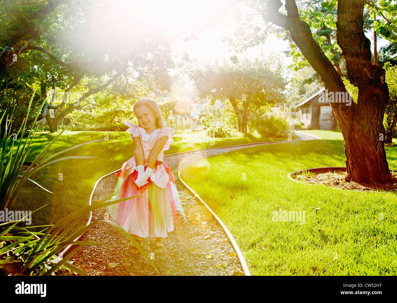 Girl in princess outfit on path in sunlight Stock Photo - Alamy
